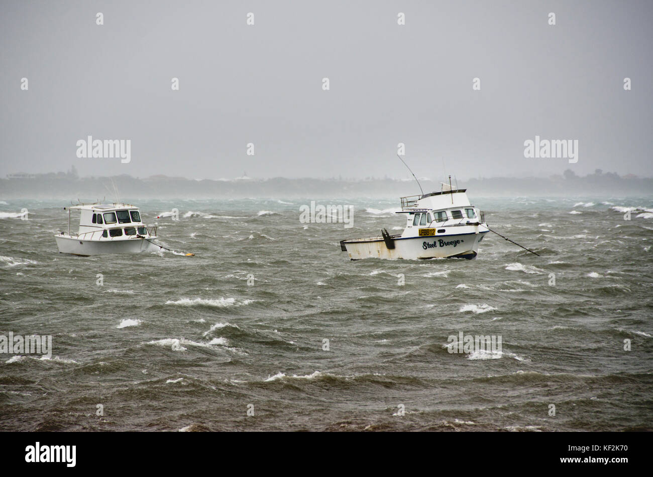 Boats at anchor being battered by severe weather conditions during a ...