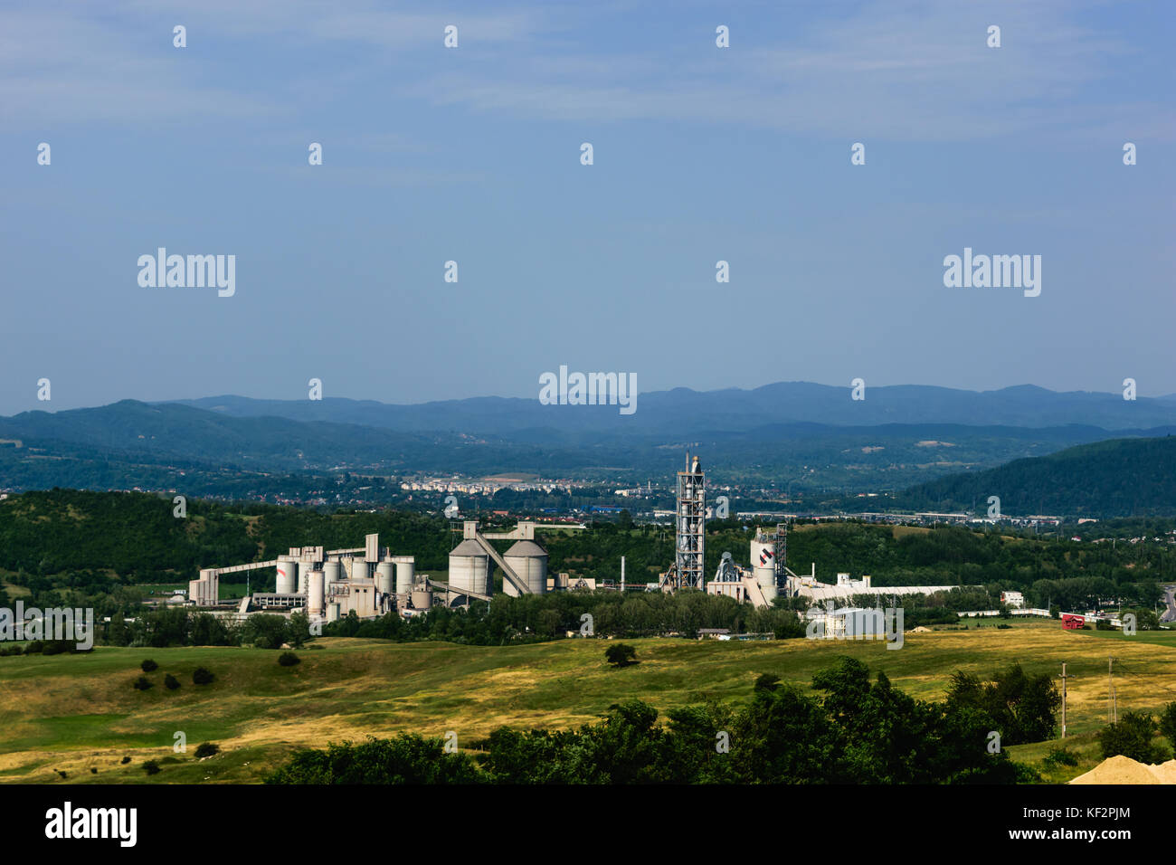 scenic view of landscape with huge cement factory surrounded by green ...