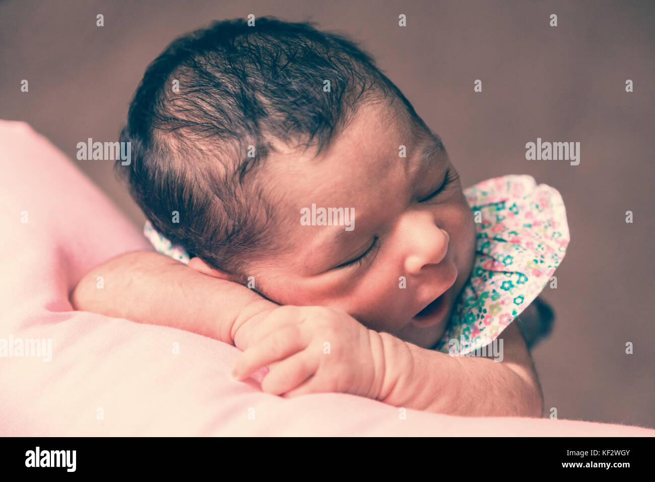 Close up portrait of a cute two weeks old newborn baby girl wearing a ...
