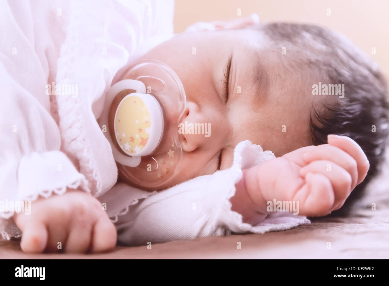 Close up portrait of a cute two weeks old newborn baby girl wearing ...