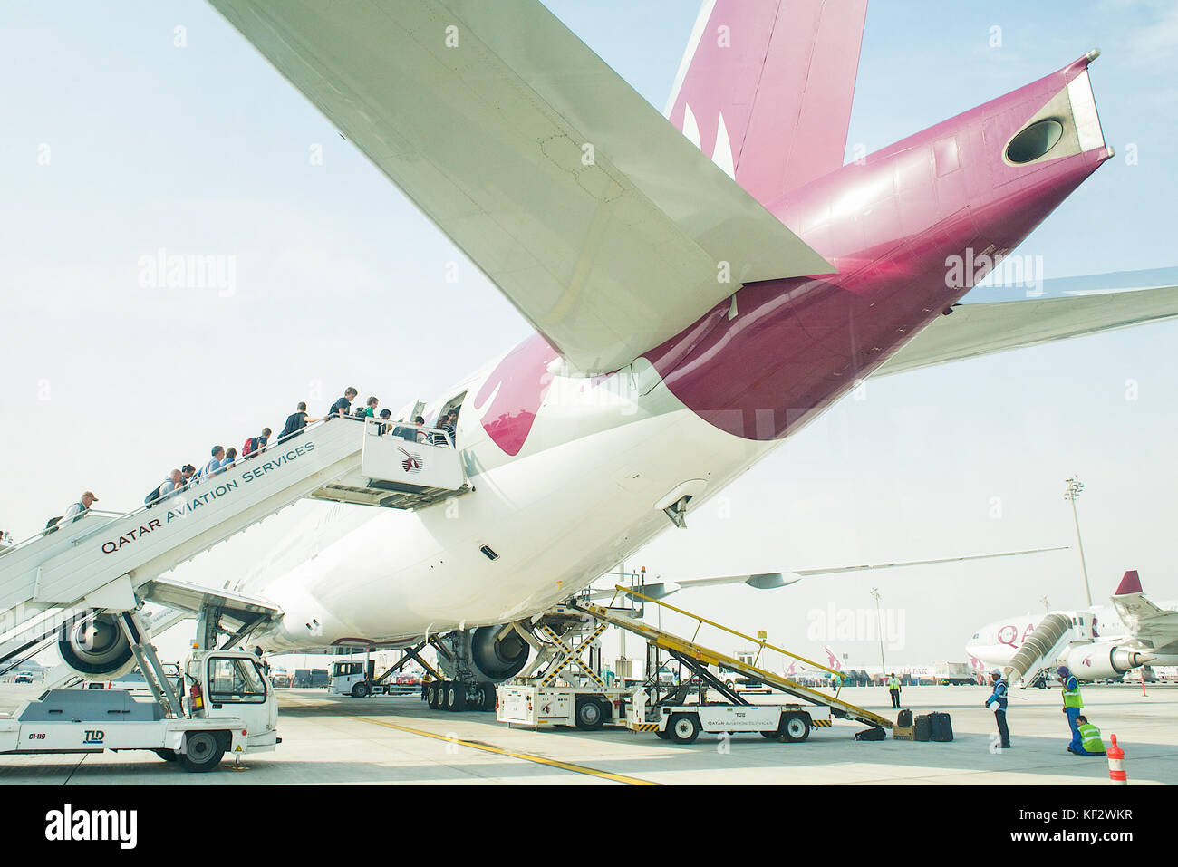 Passengers board their flight on a Qatar Boeing plane at Hamad ...