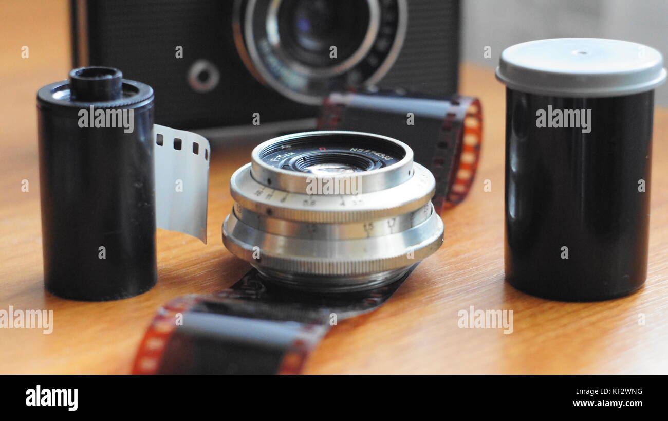A still life of accessories from old film camera: camera, lens, film ...