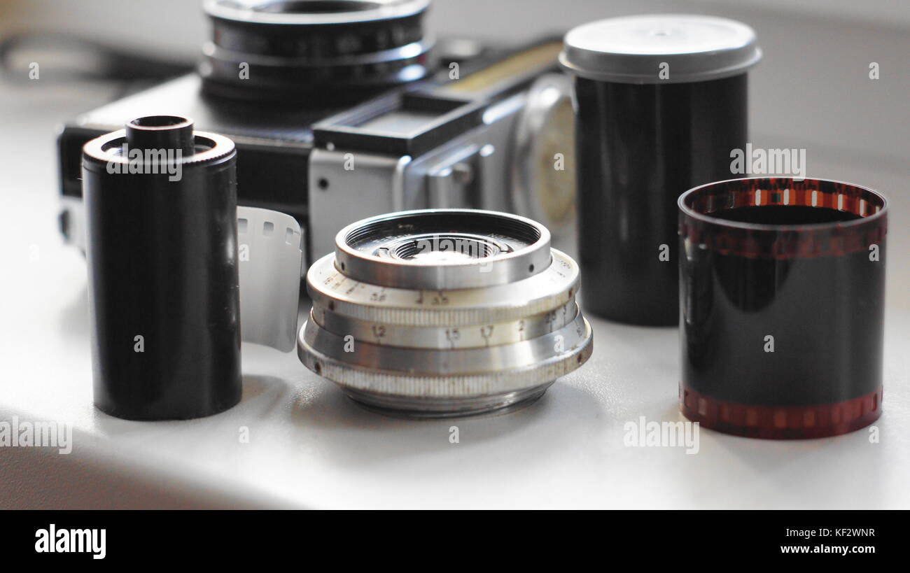 A still life of accessories from old film camera: camera, lens, film ...