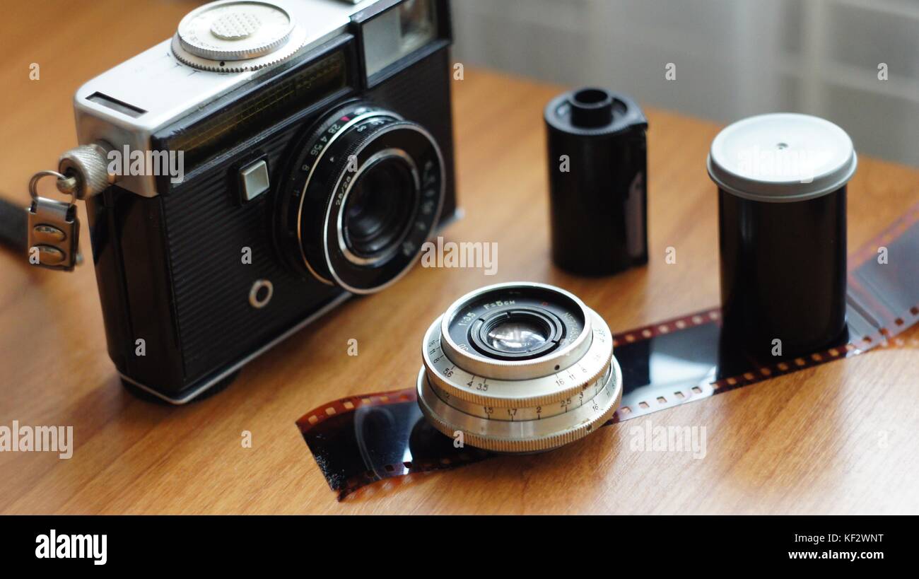 A still life of accessories from old film camera: camera, lens, film ...