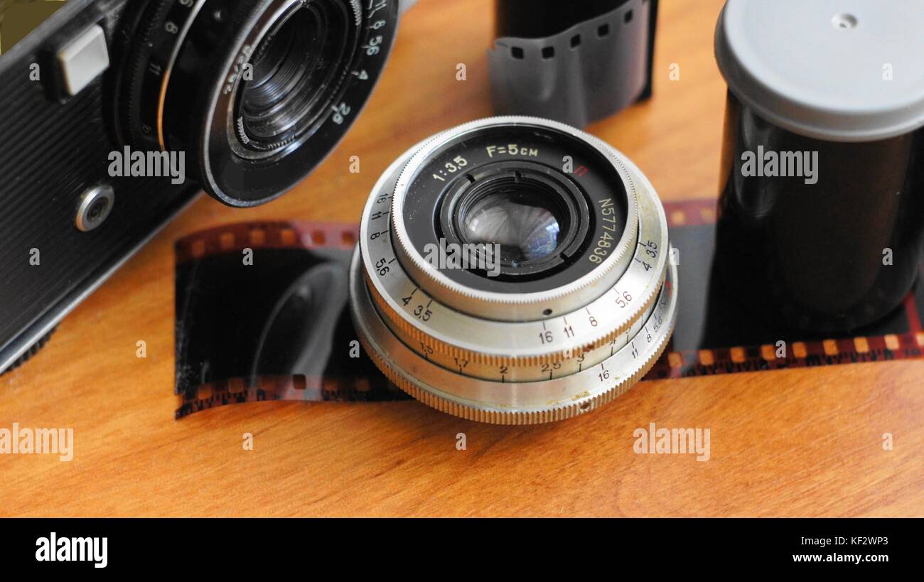 A still life of accessories from old film camera: camera, lens, film ...