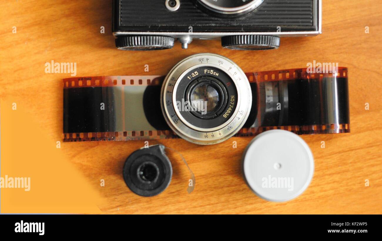 A still life of accessories from old film camera: camera, lens, film ...