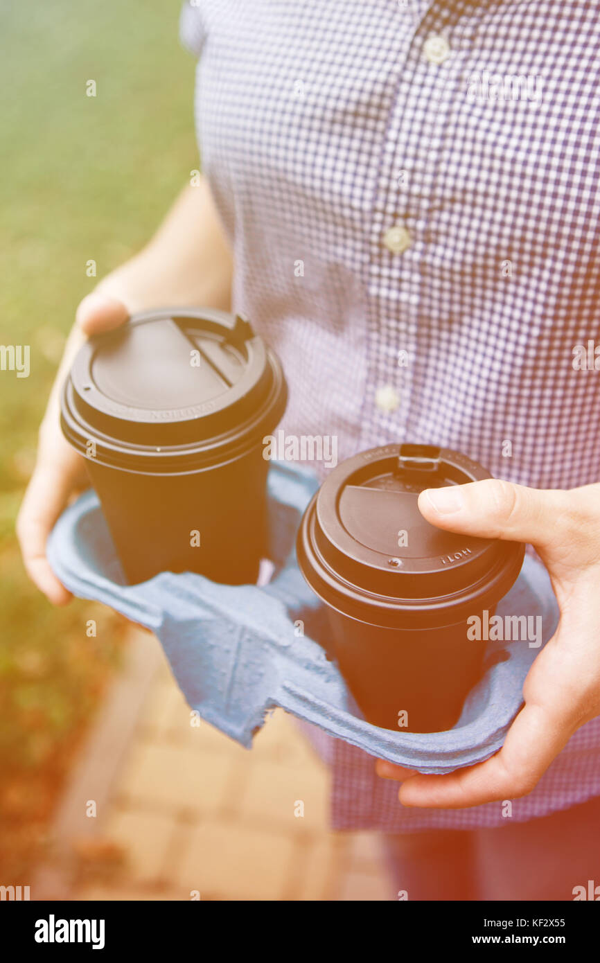 Crop person holding coffee cups Stock Photo - Alamy