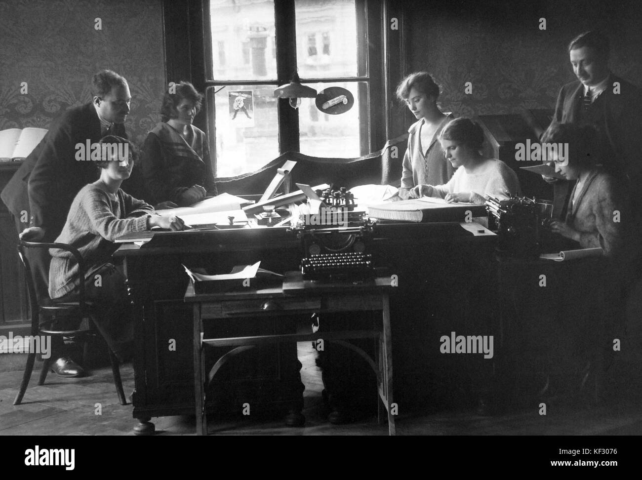 This image depicts a professional office setting, with men and women ...