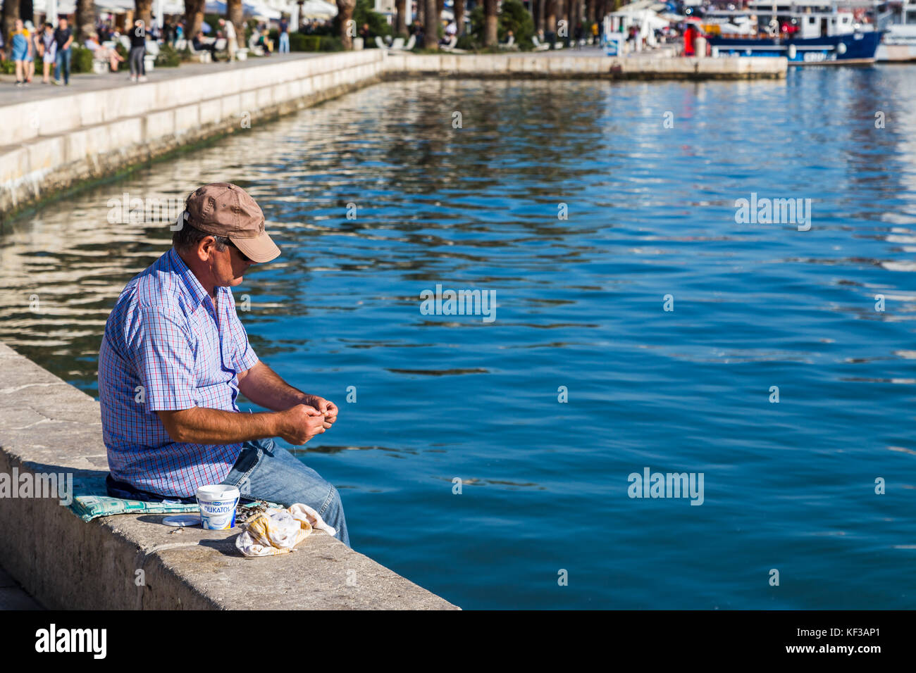A fisherman prepares his hook to cast into the water at Matejuska the ...