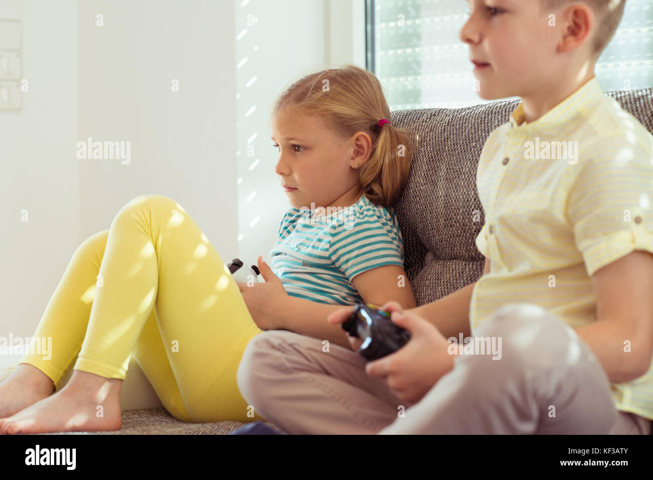 Two happy children playing video games with console at home Stock Photo ...