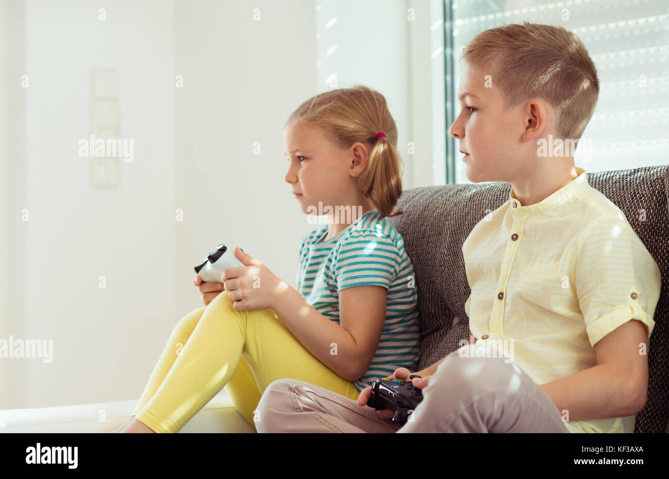 Two happy children playing video games with console at home Stock Photo ...