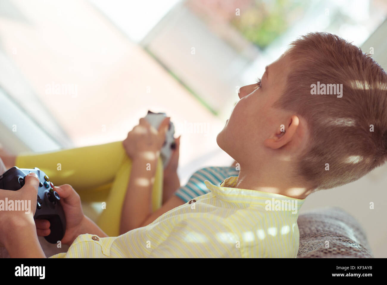 Two happy children playing video games with console at home Stock Photo ...
