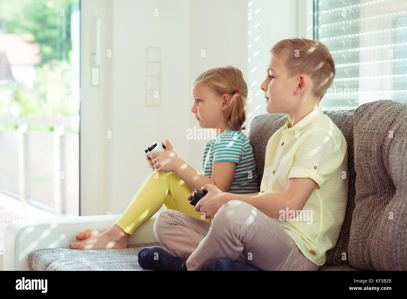 Two happy children playing video games with console at home Stock Photo ...