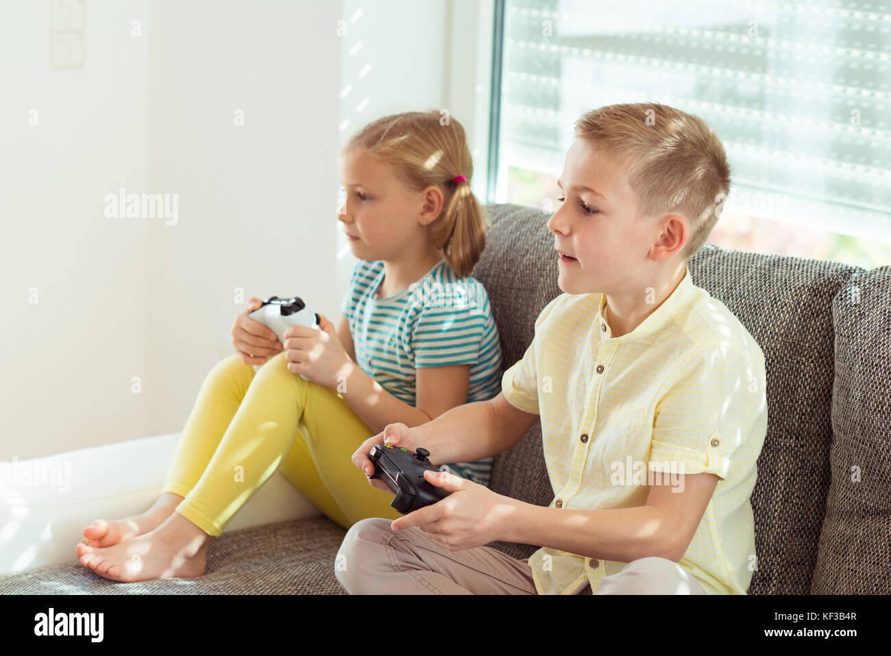 Two happy children playing video games with console at home Stock Photo ...