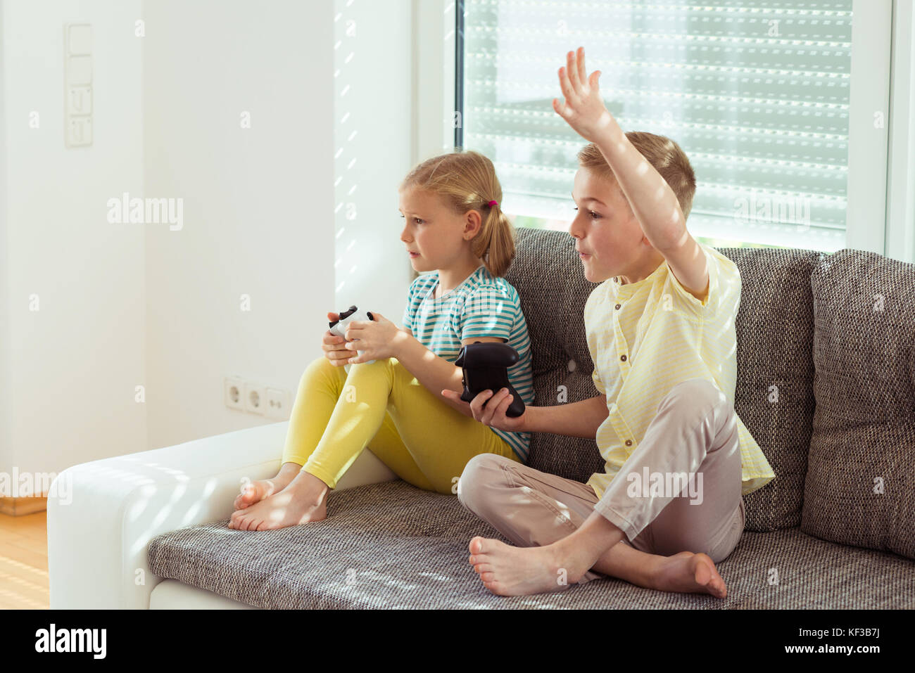 Two happy children playing video games with console at home Stock Photo ...