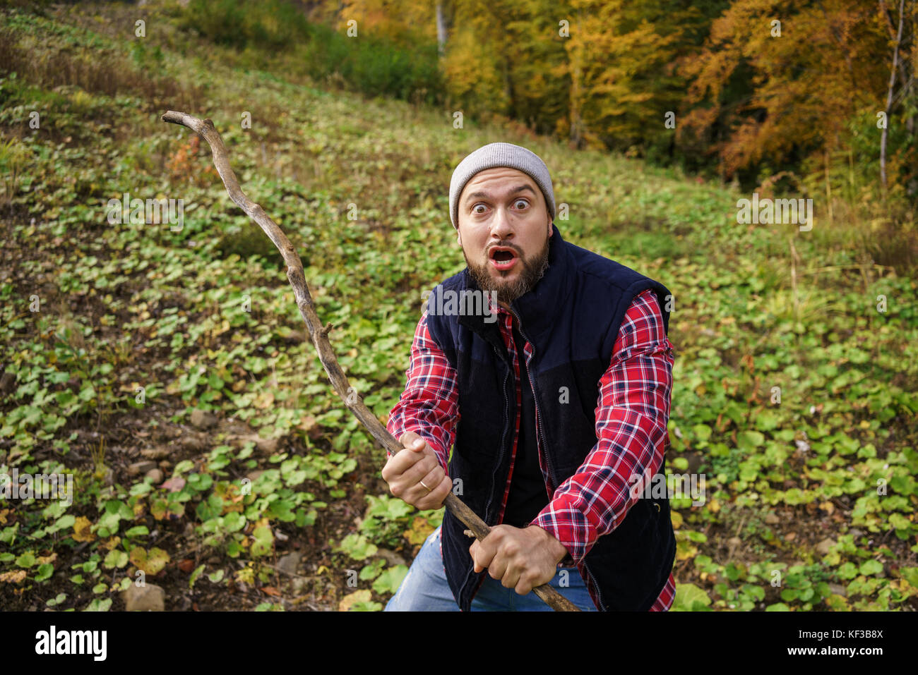 aggressive man with a stick in a hand Stock Photo - Alamy