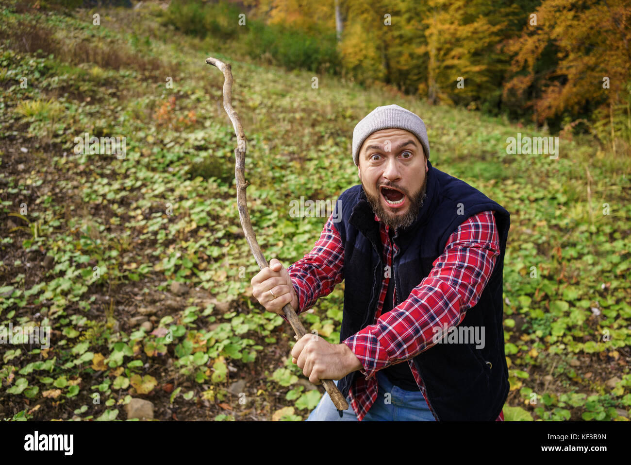 aggressive man with a stick in a hand Stock Photo - Alamy