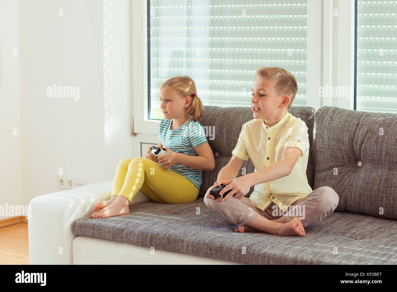 Two happy children playing video games with console at home Stock Photo ...