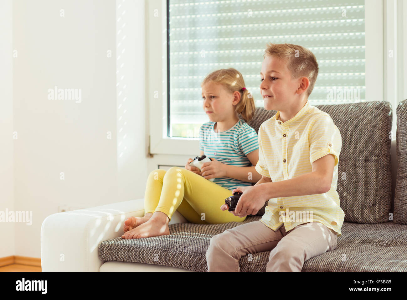 Two happy children playing video games with console at home Stock Photo ...