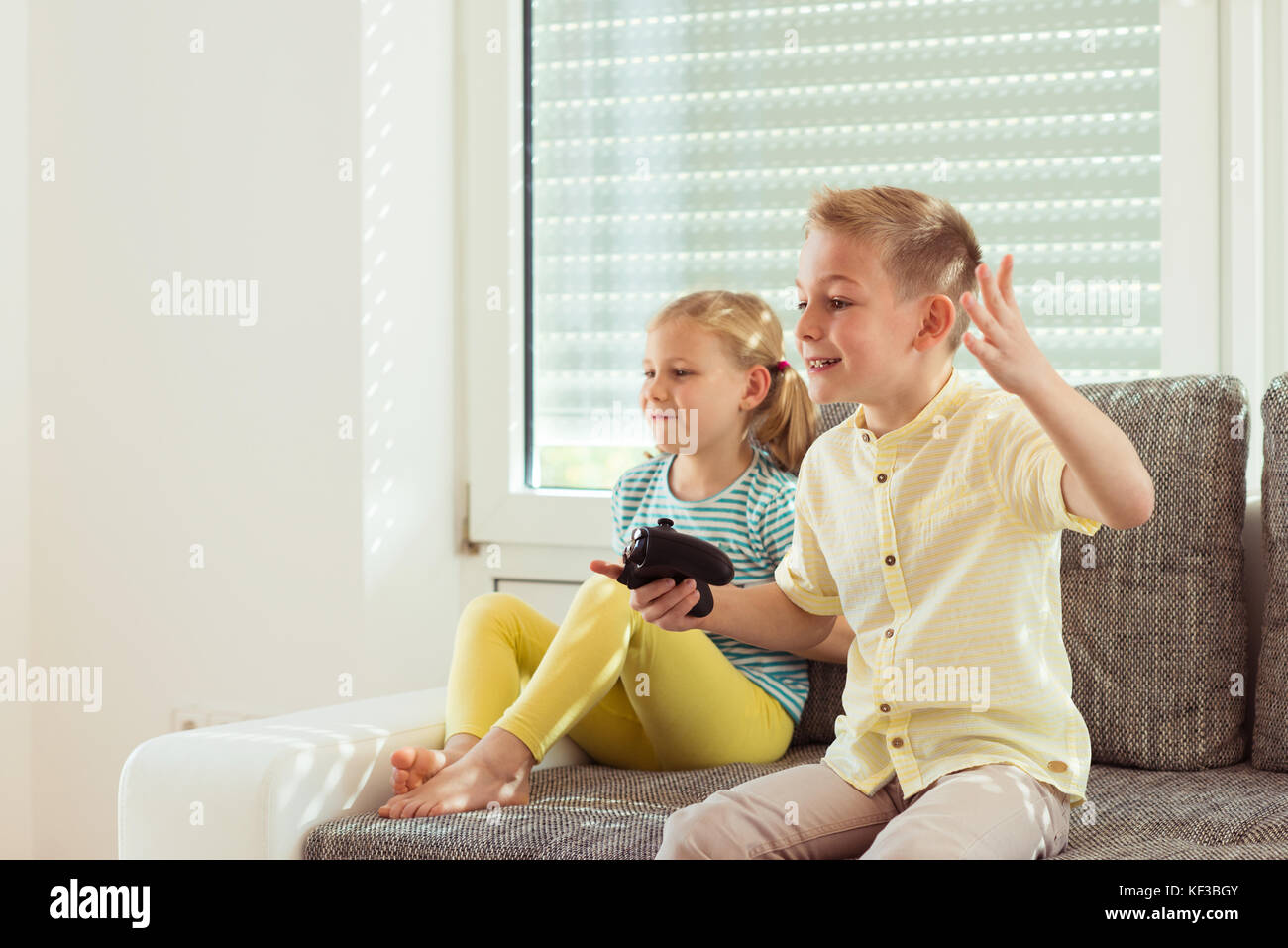 Two happy children playing video games with console at home Stock Photo ...