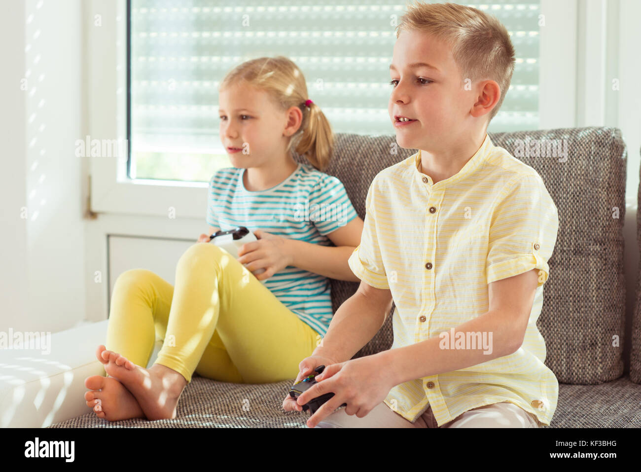 Two happy children playing video games with console at home Stock Photo ...