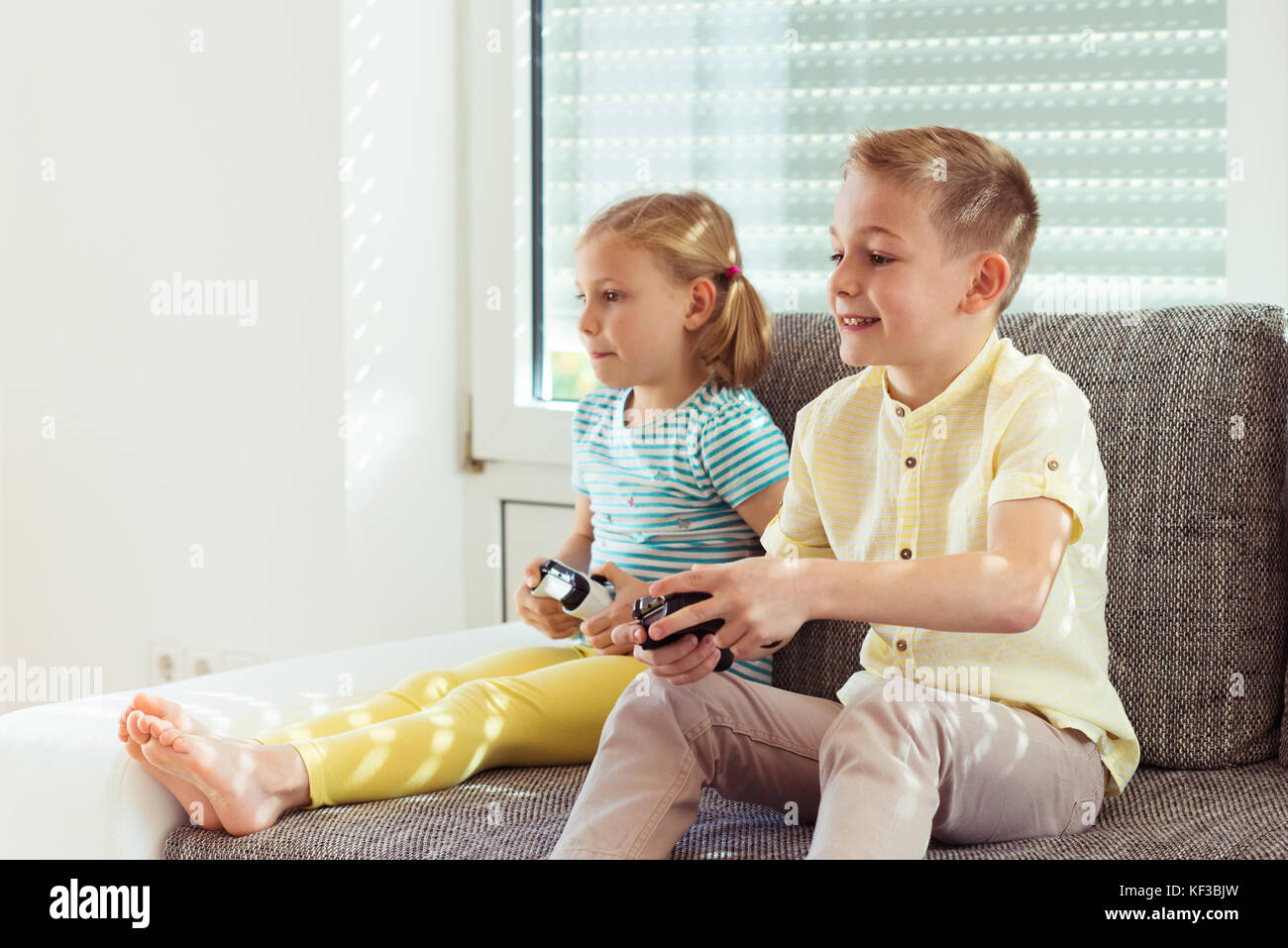 Two happy children playing video games with console at home Stock Photo ...