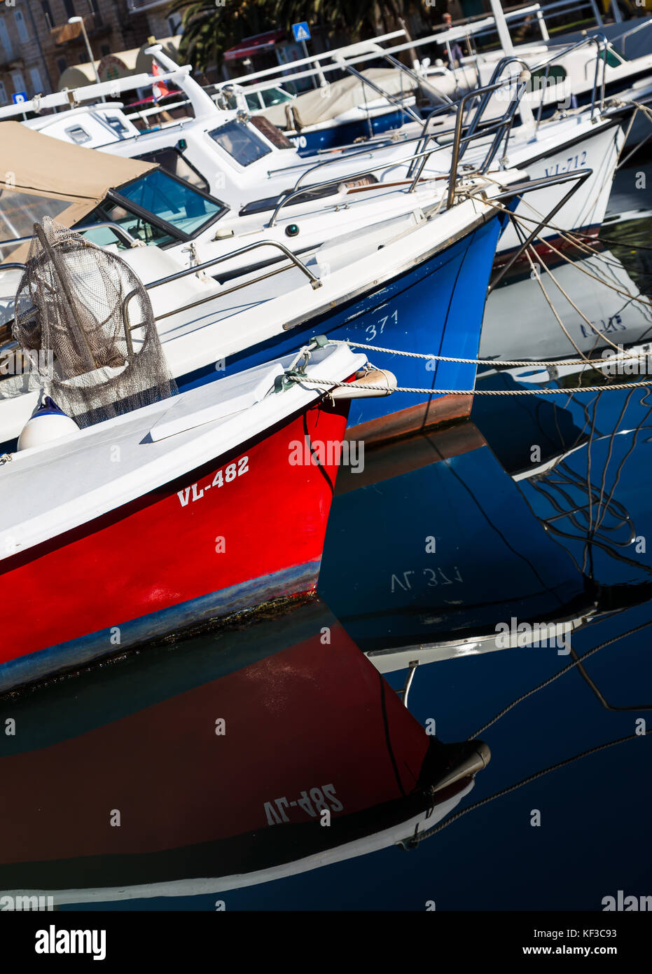 Slanted image of the bows of some small colourful fishing boats ...