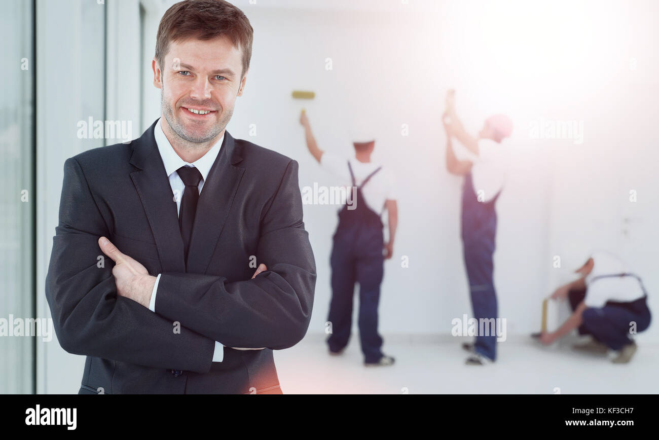 portrait of a smiling owner. against the backdrop of a team of builders ...