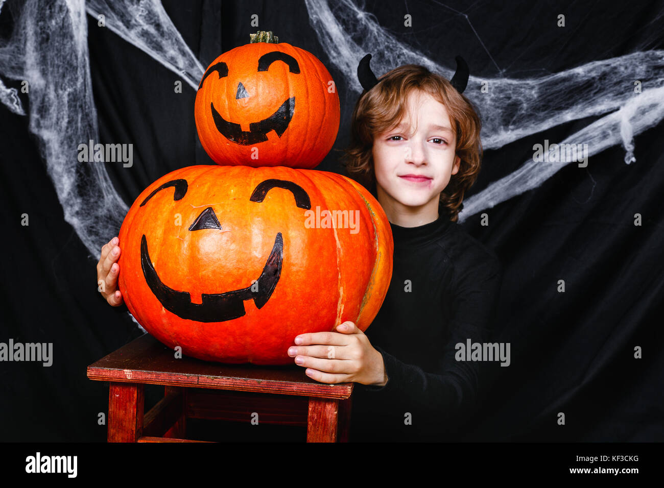 A young boy in halloween costume with pumpkins having fun on party ...