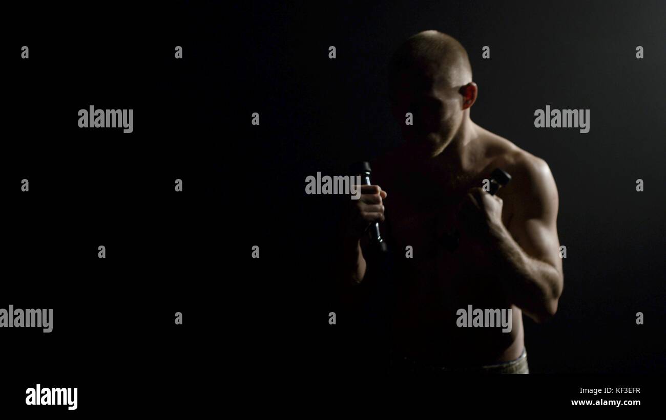 Fight with shadow on dark background. Fighter in studio. side view ...