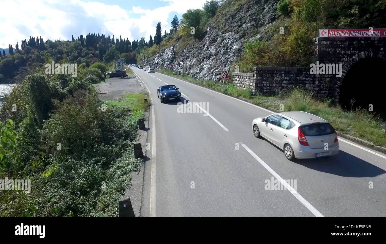 Car going on a road near the river, aerial view. Footage. Aerial view ...