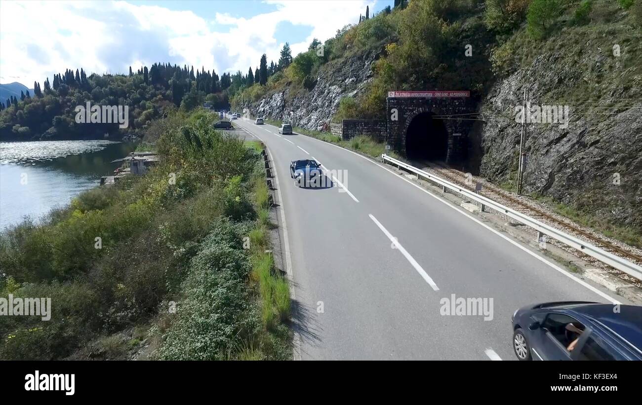 Car going on a road near the river, aerial view. Footage. Aerial view ...