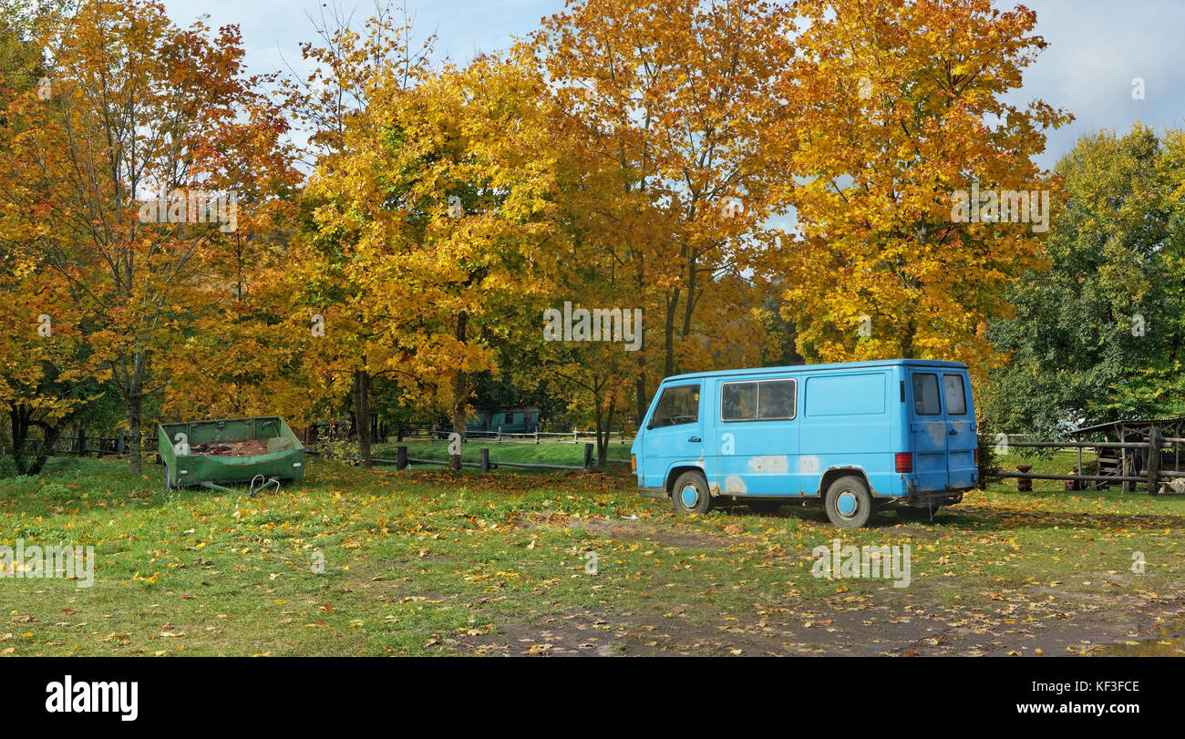 Old defective no name cars are forgotten in a dump in an autumn forest ...