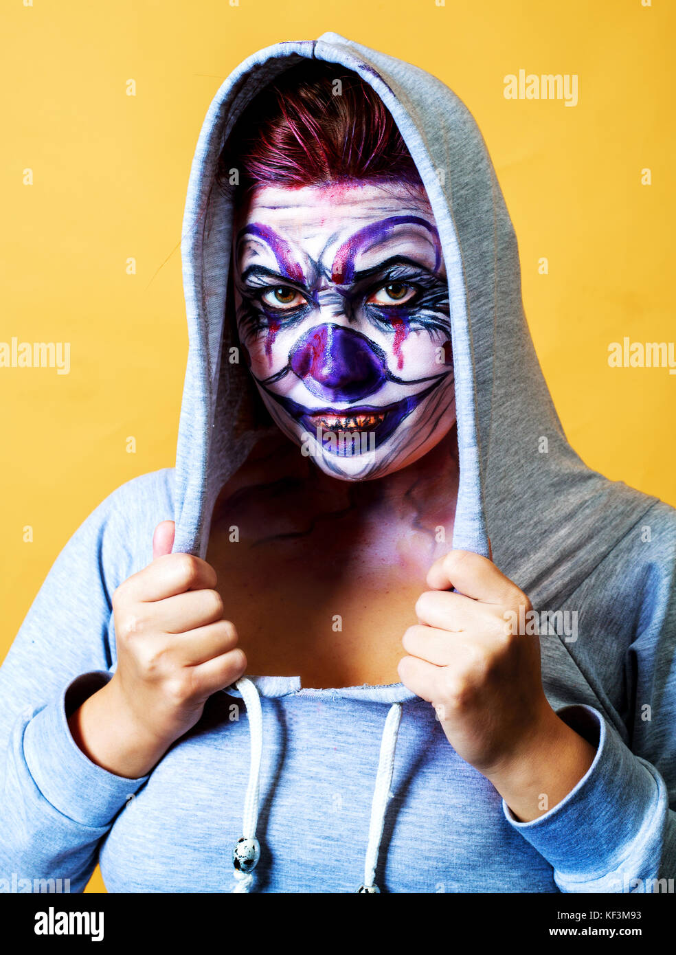 young woman with body painting on her face, ugly scary clown, Halloween ...