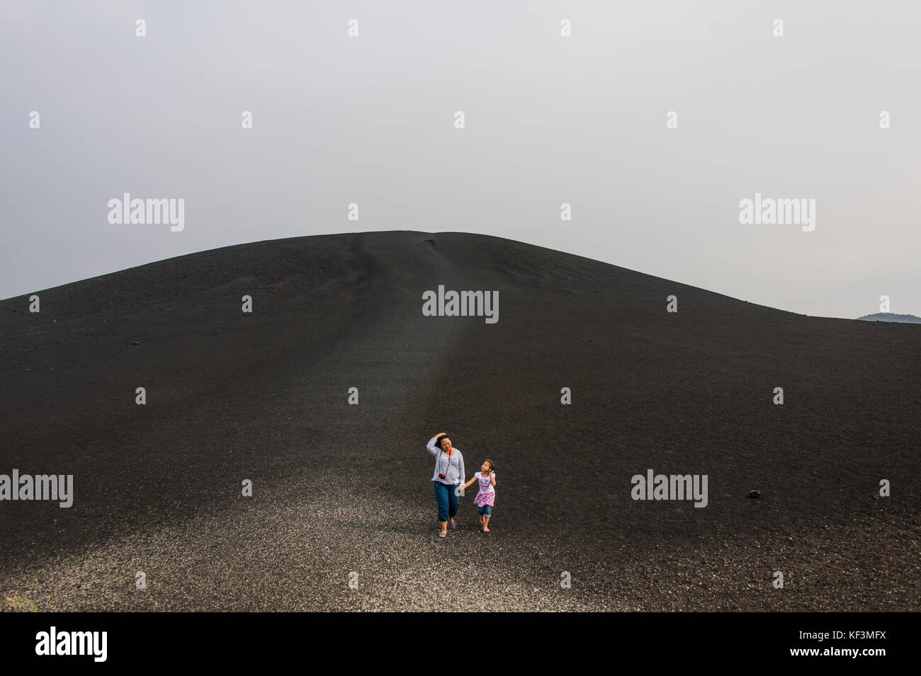 Mother walk with her daughter down a little volcanic cone, Craters of ...