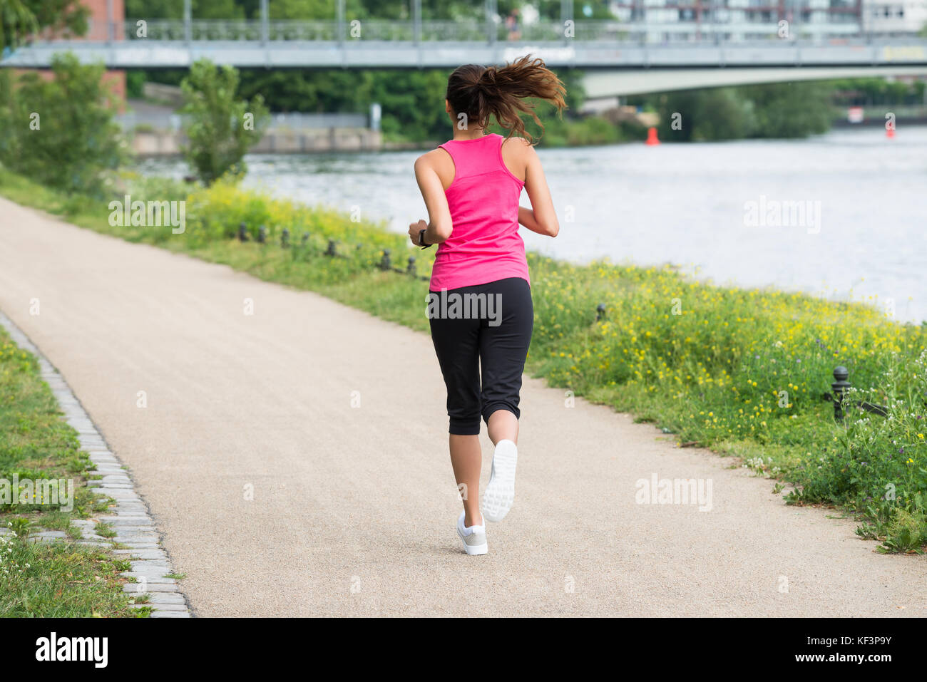 Rear View Of Sporty Young Woman Running On Path Stock Photo - Alamy