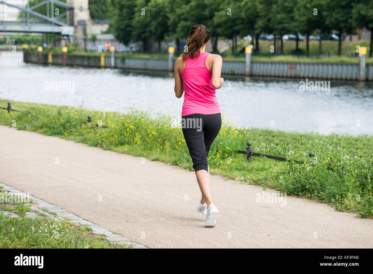 Rear View Of Sporty Young Woman Running On Path Stock Photo - Alamy
