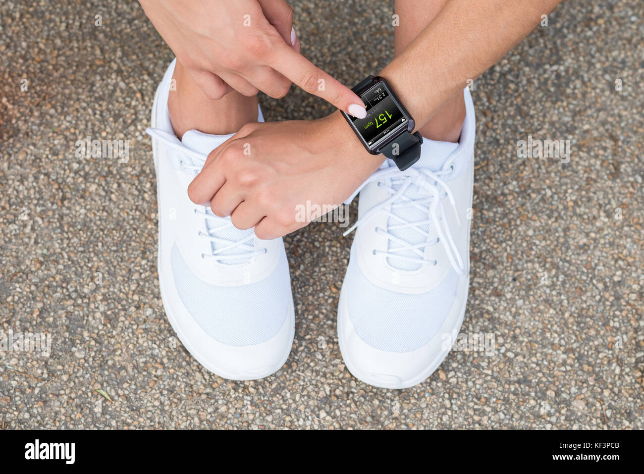 Elevated View Of A Female Athlete In White Shoes Touching At Smart ...