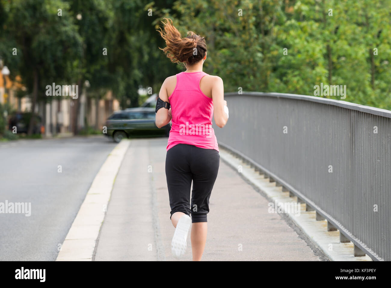 Rear View Of Sporty Young Woman Running On Sidewalk In Morning Stock ...