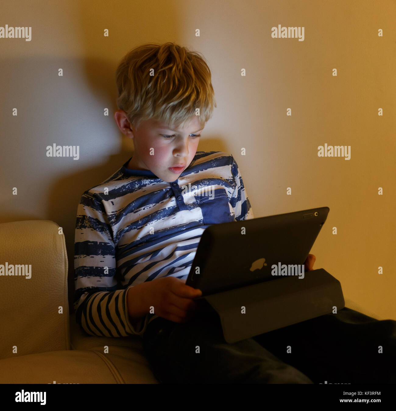 Boy watching Ipad and face is lit by the screen Stock Photo - Alamy