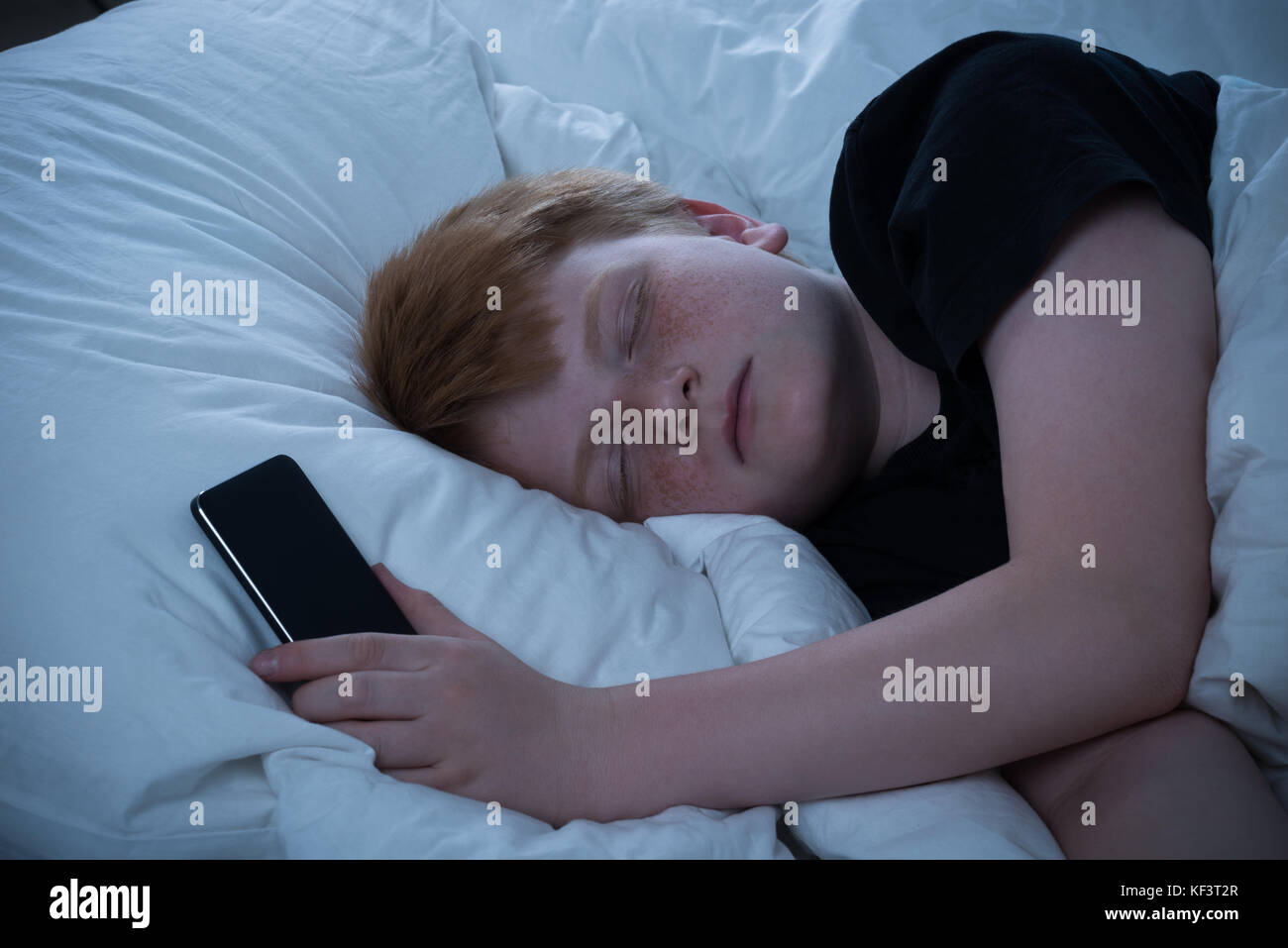 Boy Sleeping On Bed With His Mobile Phone Stock Photo - Alamy