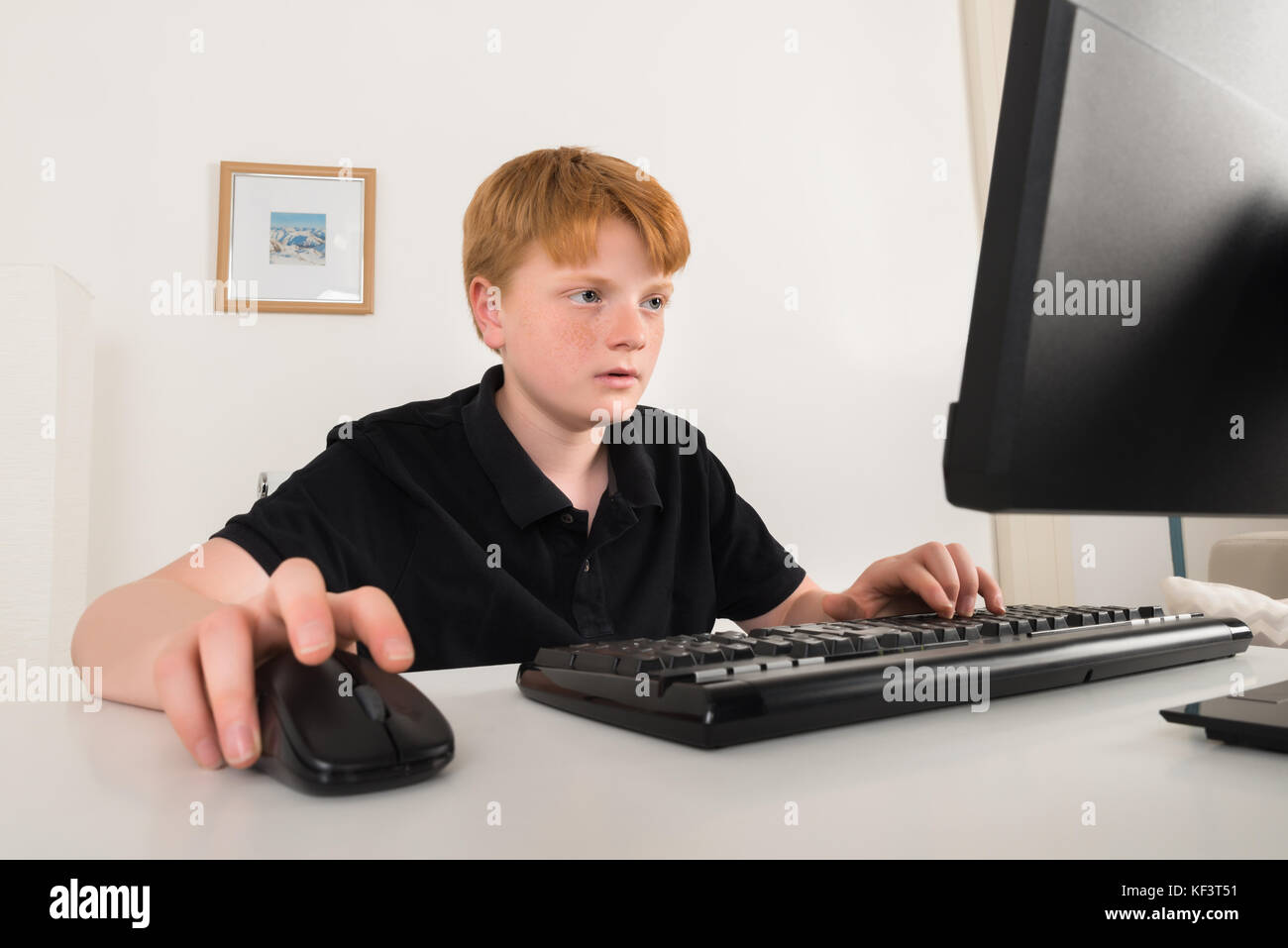 Boy sitting at computer typing hi-res stock photography and images - Alamy