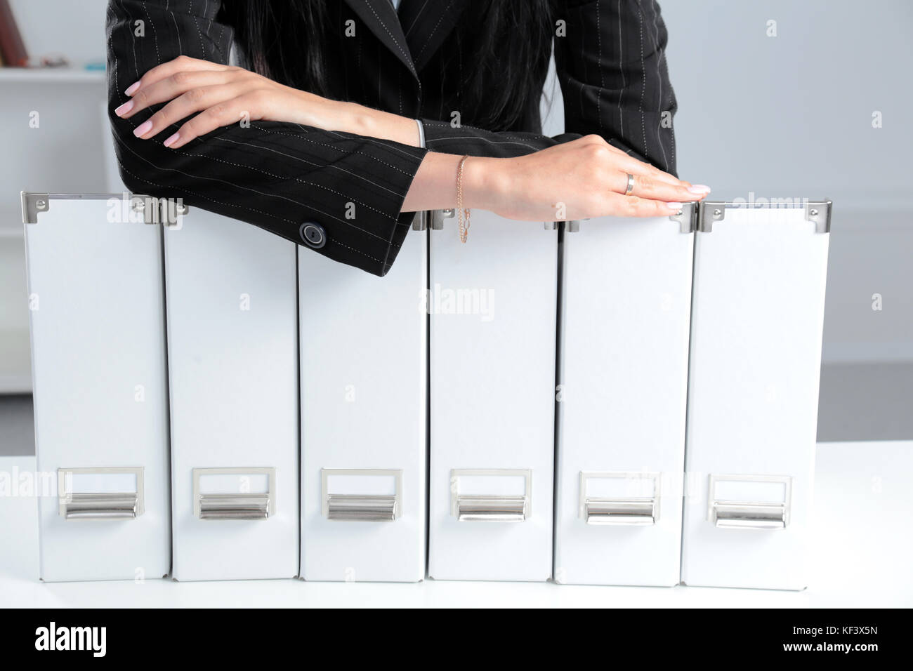 businesswomen holding data files on binder shelves background Stock ...