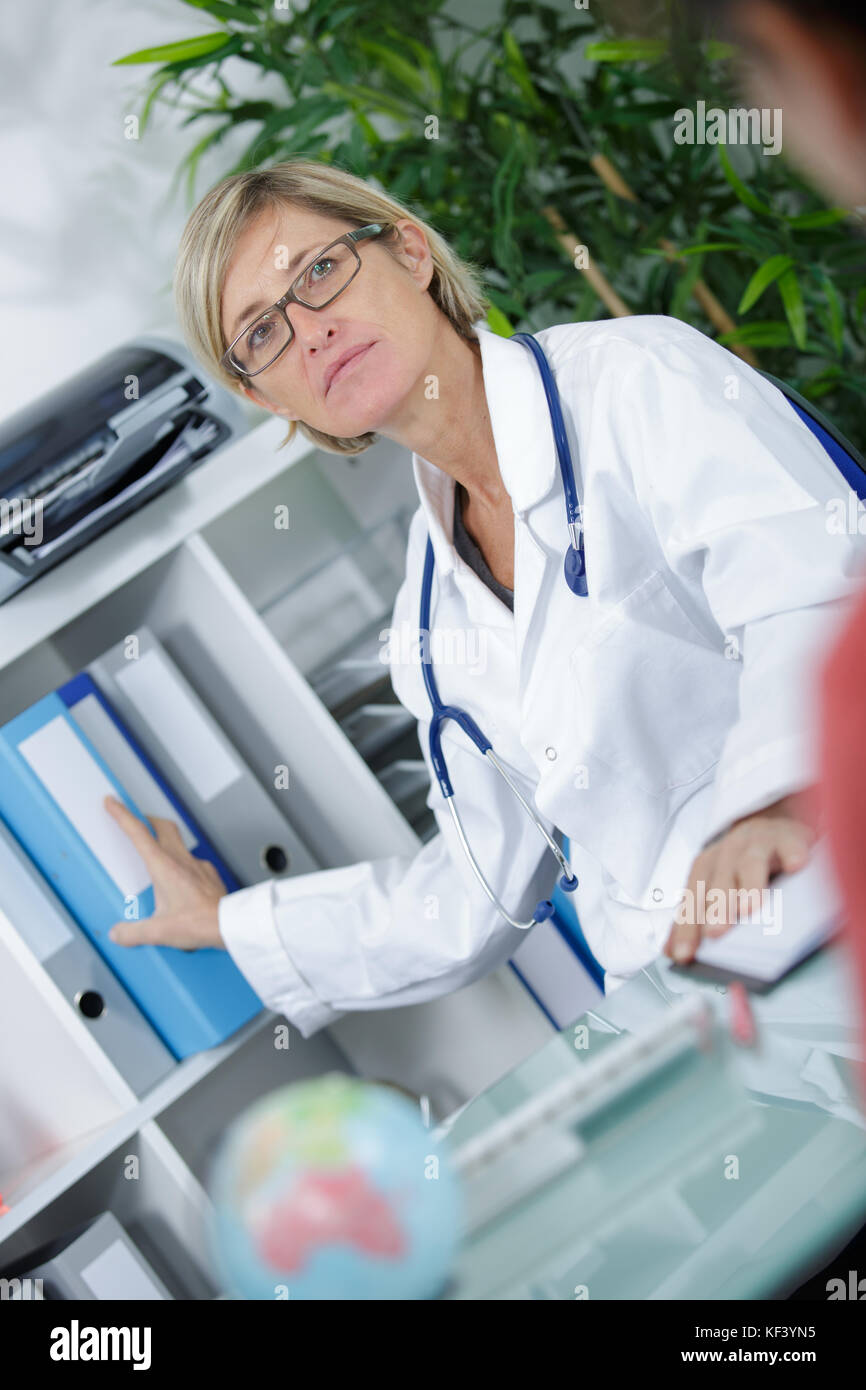 doctor taking a file out from the shelf Stock Photo - Alamy
