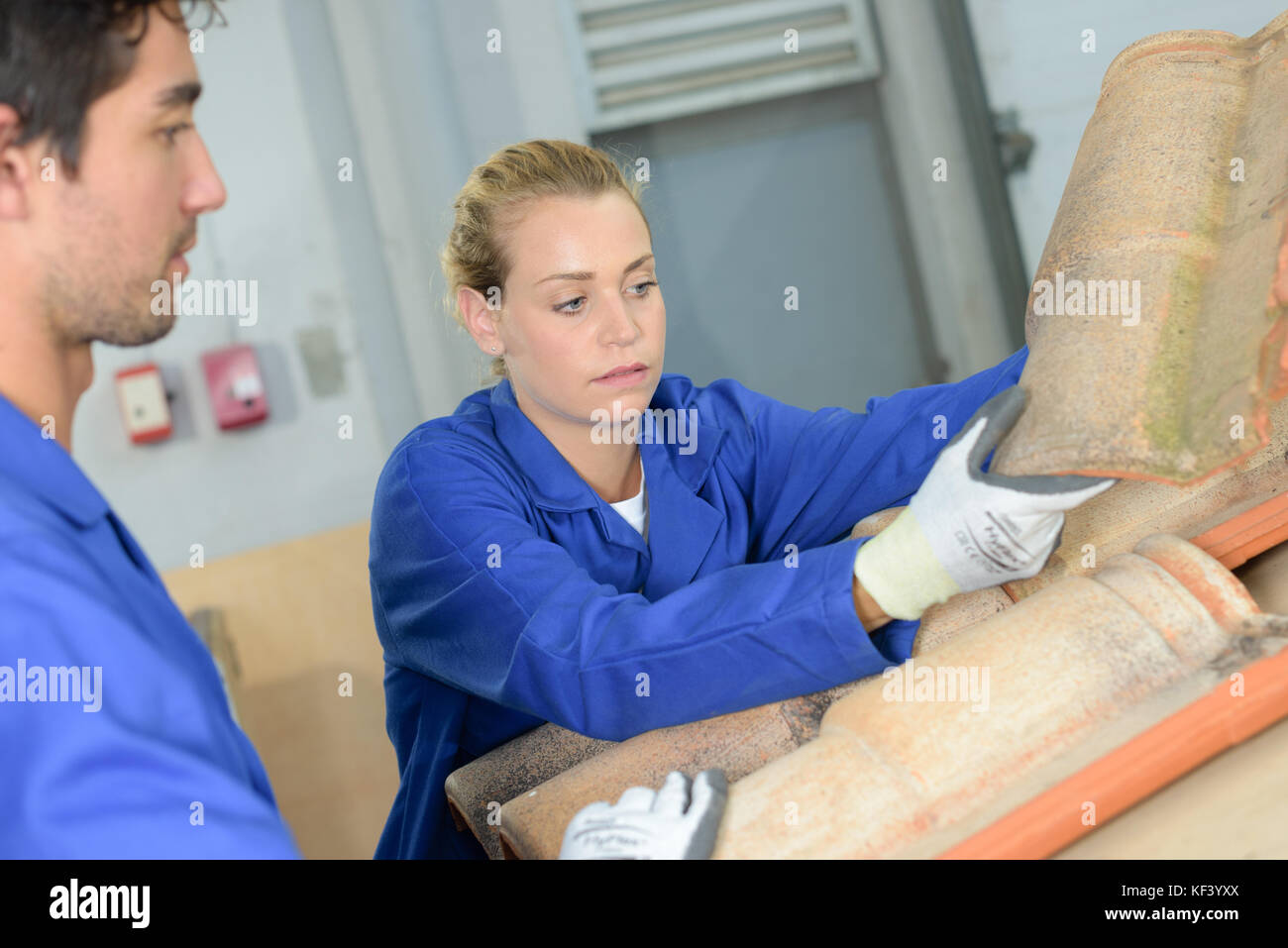 Apprentices learning to fit roof tiles Stock Photo - Alamy