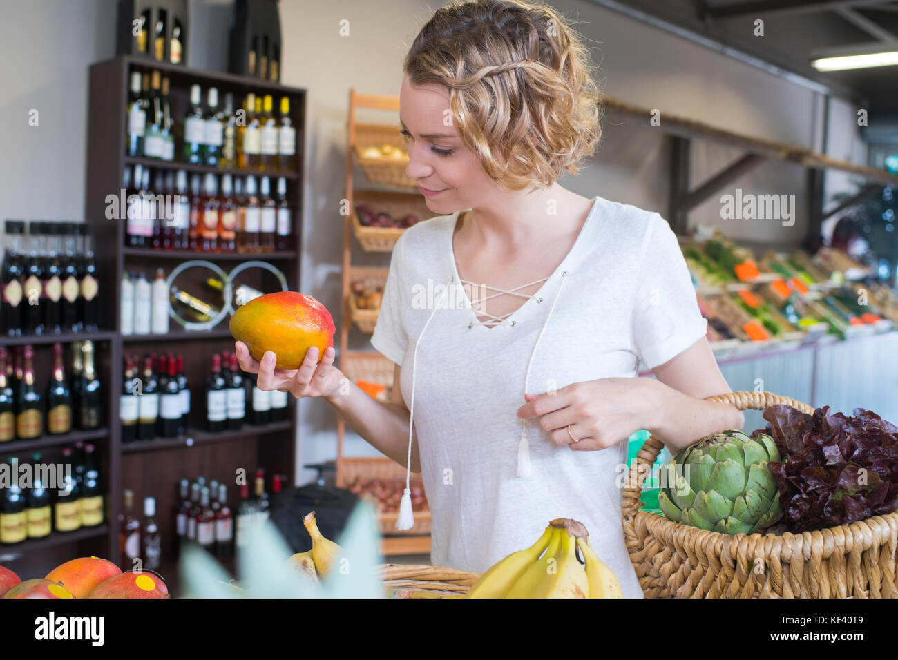 happy young woman customer choosing mango Stock Photo - Alamy