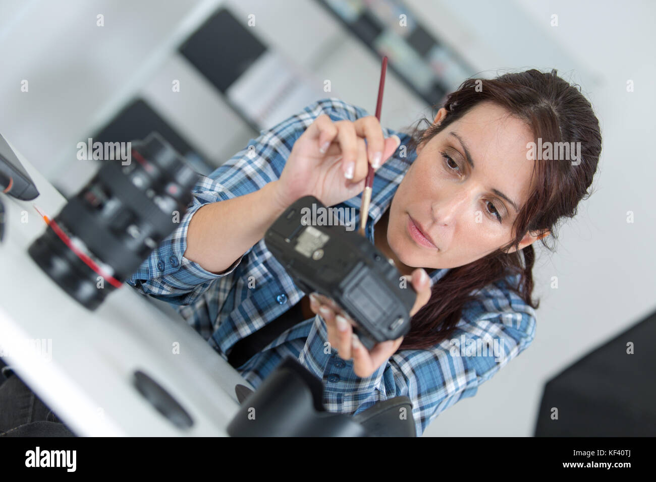 Woman working on camera flash unit Stock Photo - Alamy