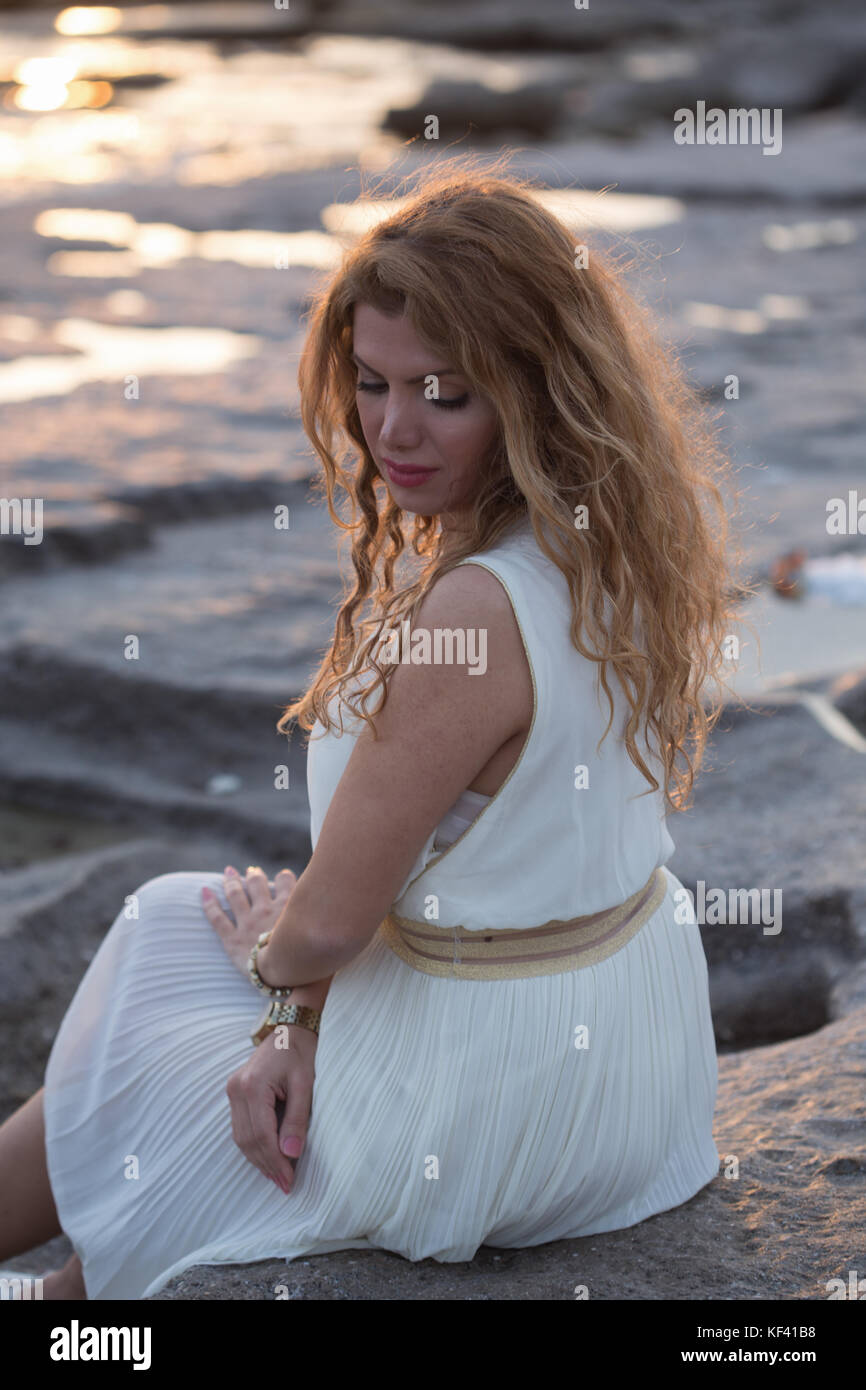 Beautiful lady in ivory dress thinking Stock Photo - Alamy