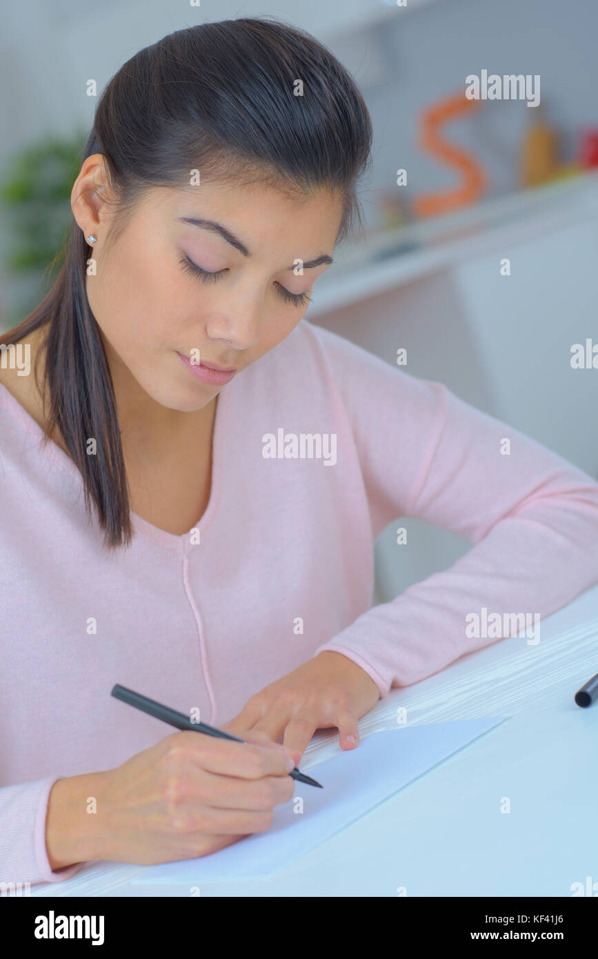 female writing on note pad Stock Photo - Alamy