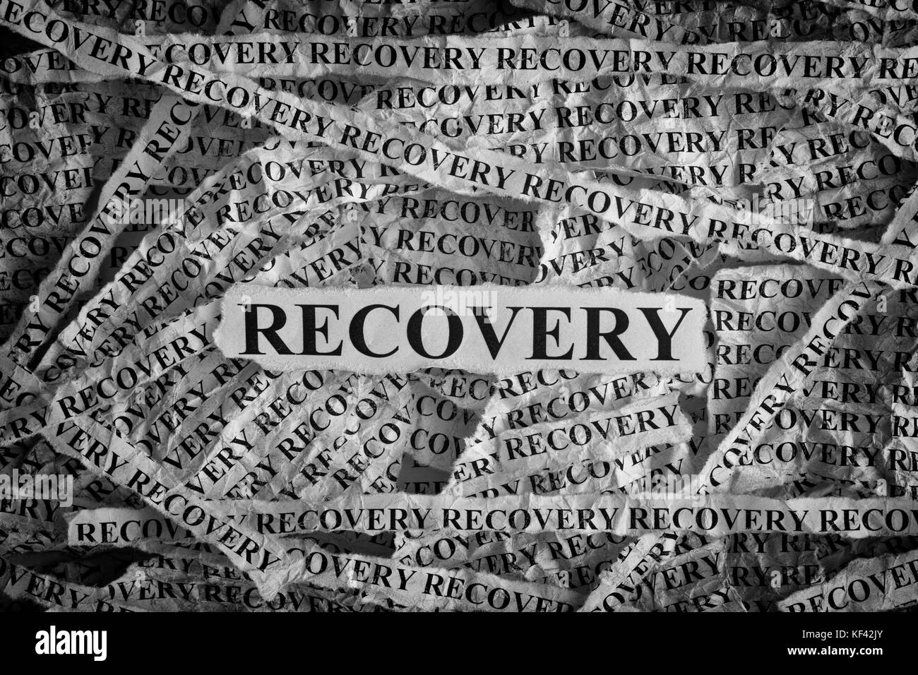 Recovery. Torn pieces of paper with word Recovery. Concept Image. Black ...